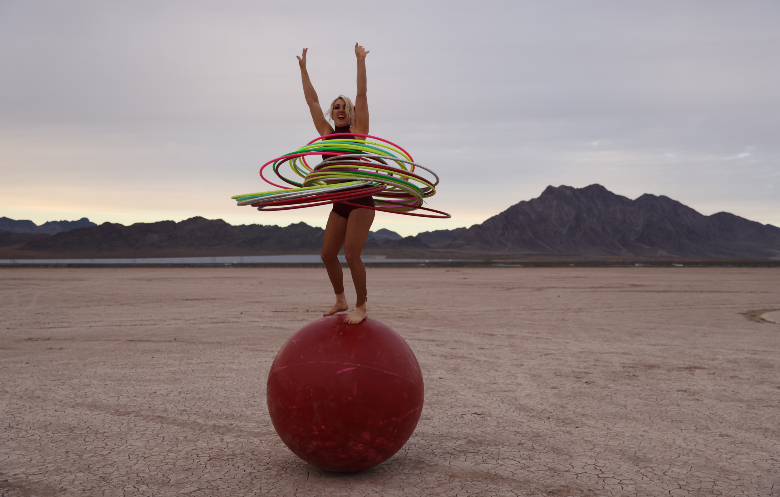 Most hula hoops spun simultaneously while balancing on a giant rolling ...